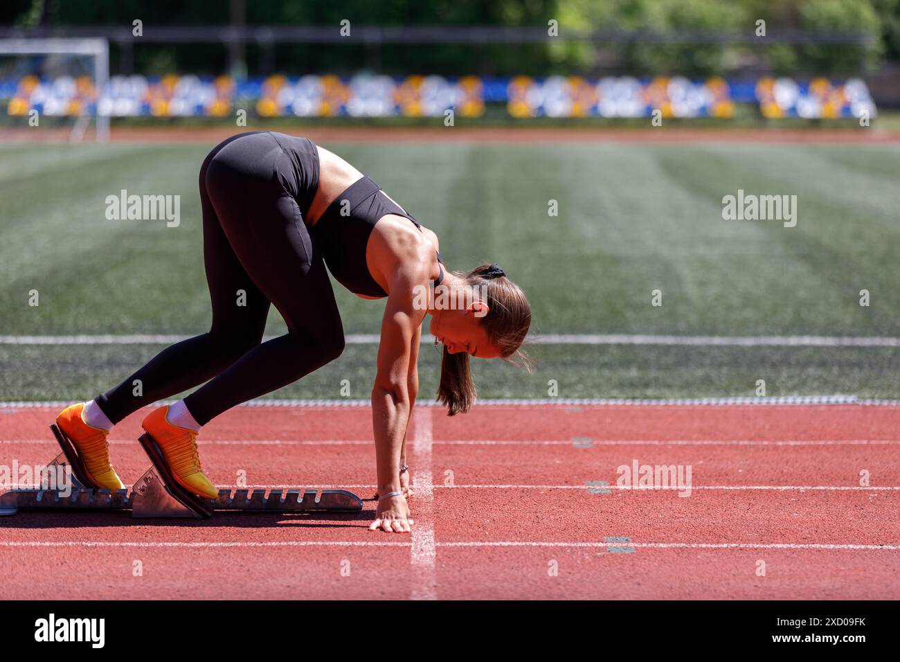 Strong female sprinter at the 100m start on starting blocks Stock Photo ...