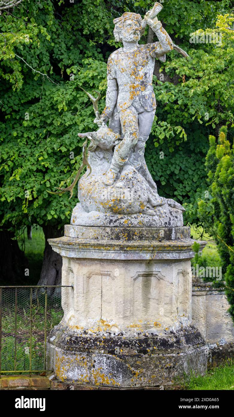 Stone sculpture of hunter blowing horn with stag in the gardens at ...