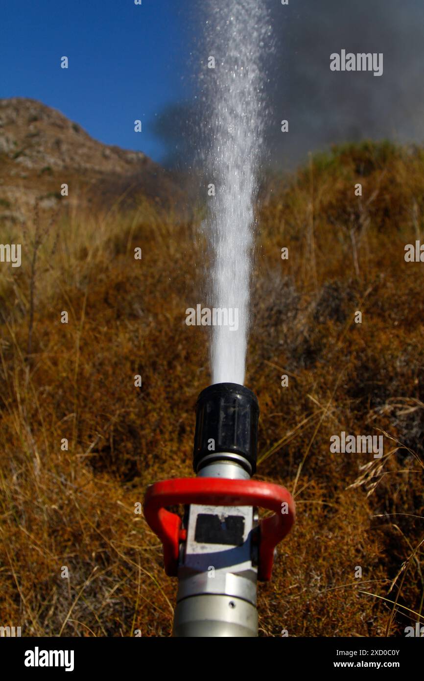 The fireman's hand holds a fire hose to extinguish a fire.Extinguish ...