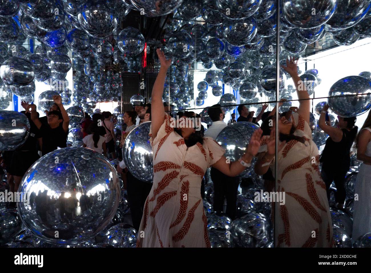 A woman is bouncing silver Mylar balloons at "Affinity" at Summit One ...