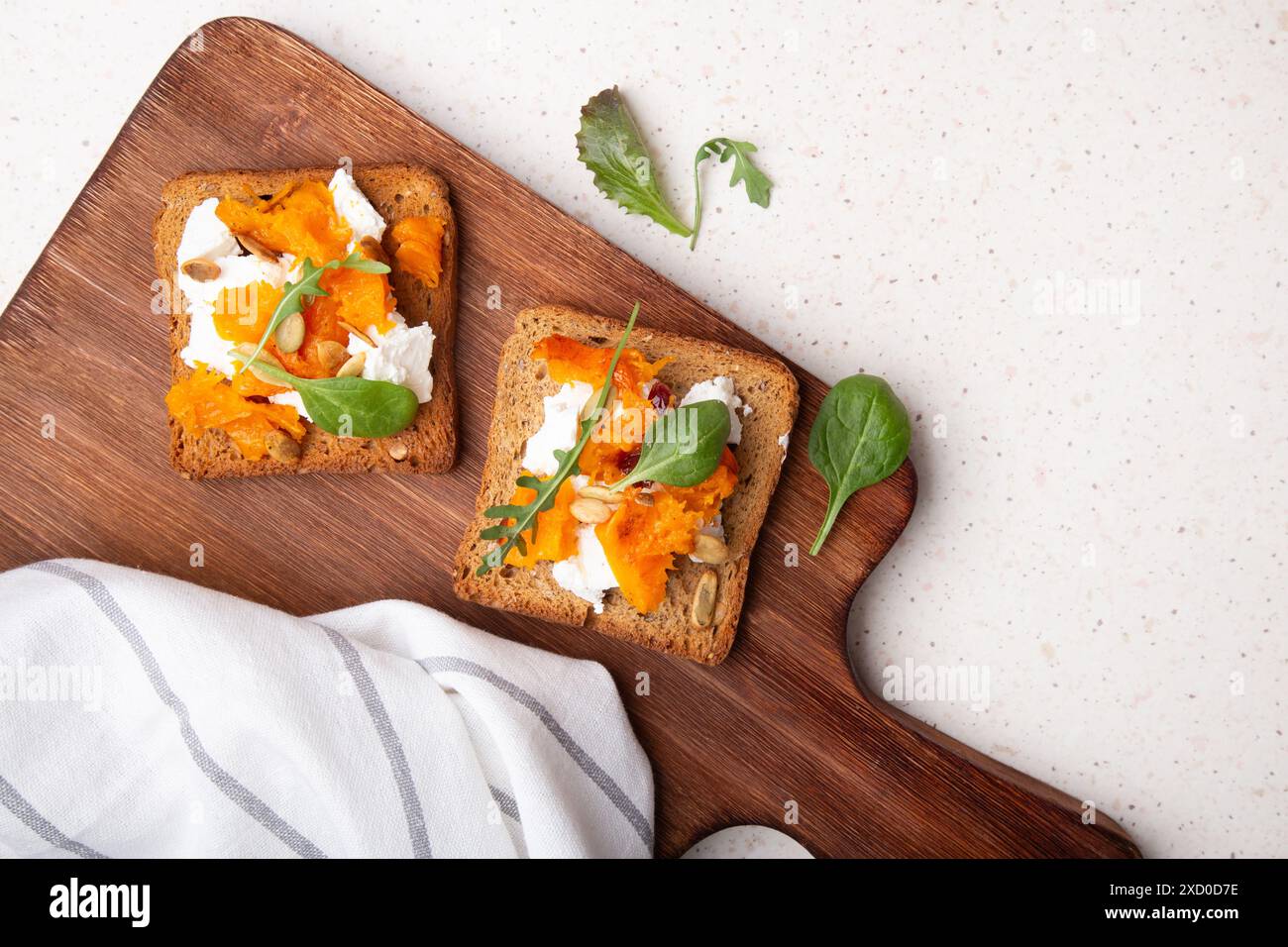 Healthy pumpkin toast with crumbled cheese and seed garnish for a ...