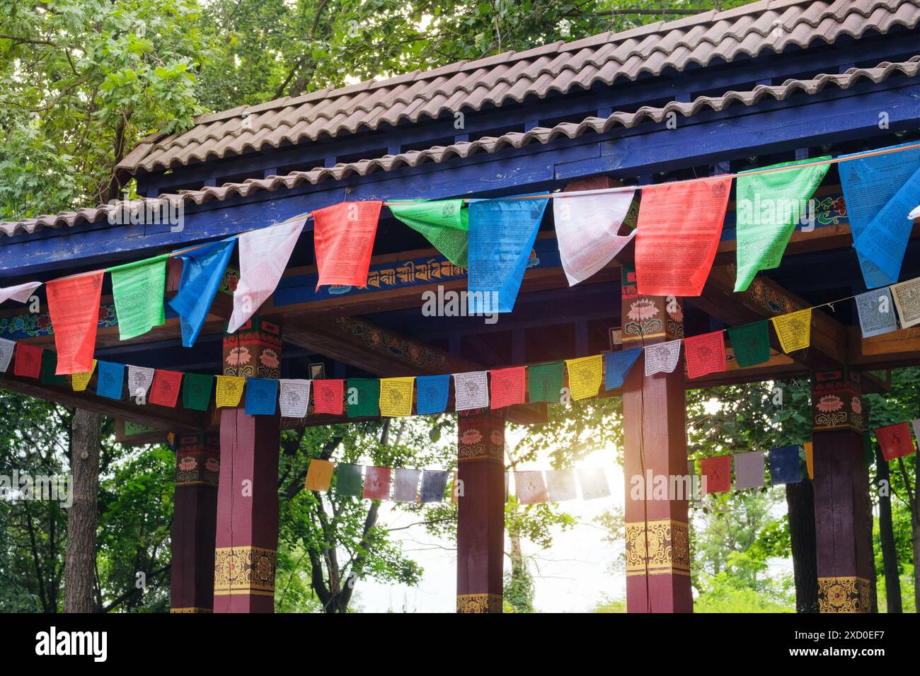 Buddhist tibetan prayer flags is flying on wind on background of trees ...