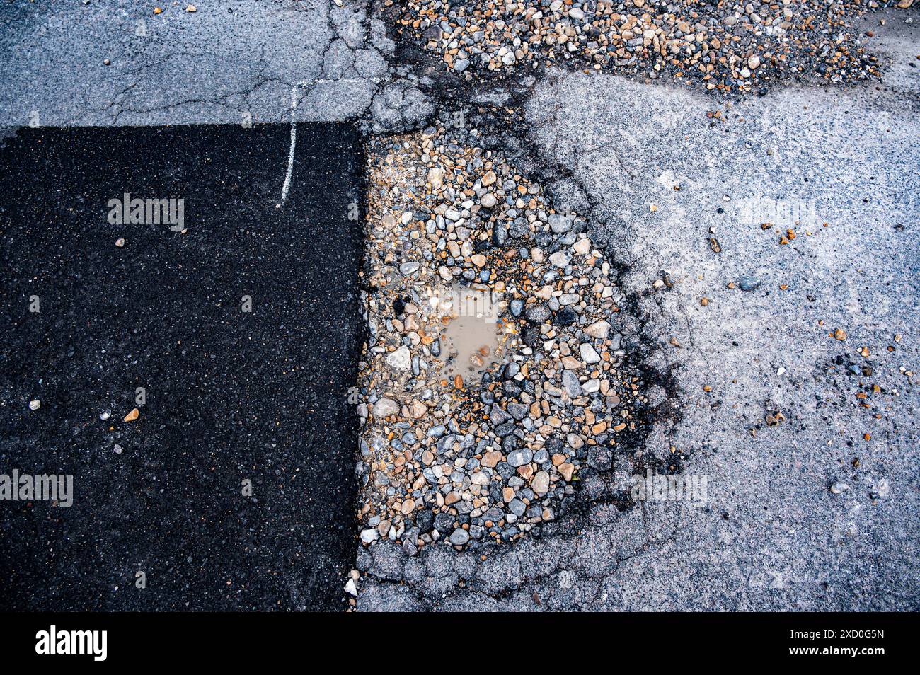 Section of road just repaired gets a new pothole Stock Photo - Alamy