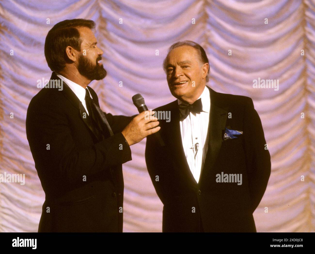 GLEN CAMPBELL American country singer on stage with actor Bob Hope at a ...