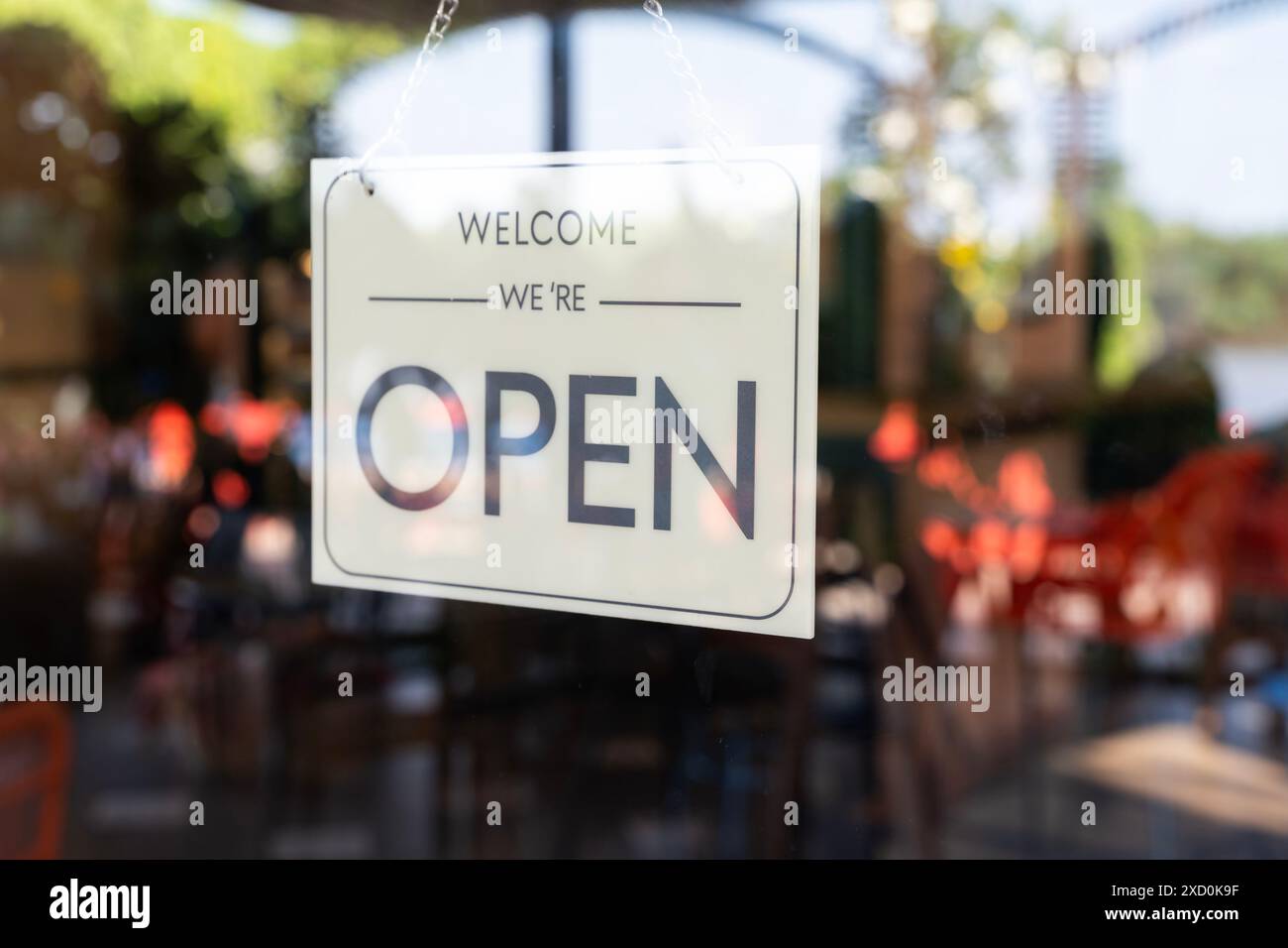 A sign hanging from a window that says "Welcome We're Open Stock Photo ...