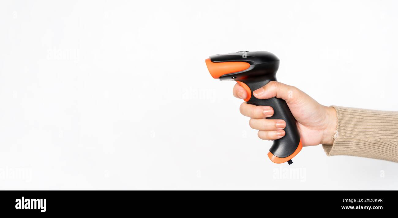 A person is holding a black and orange barcode scanner. Concept of ...