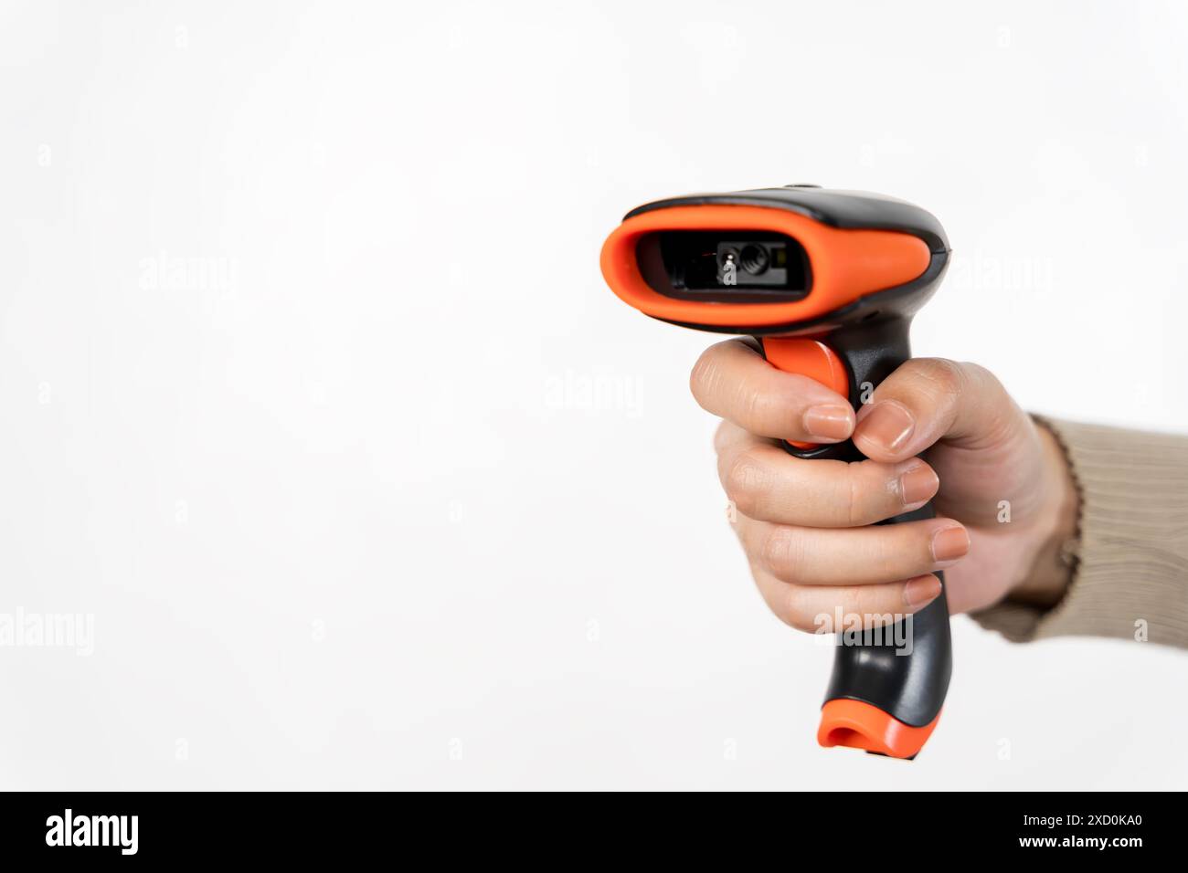 A person is holding a black and orange barcode scanner. Concept of ...