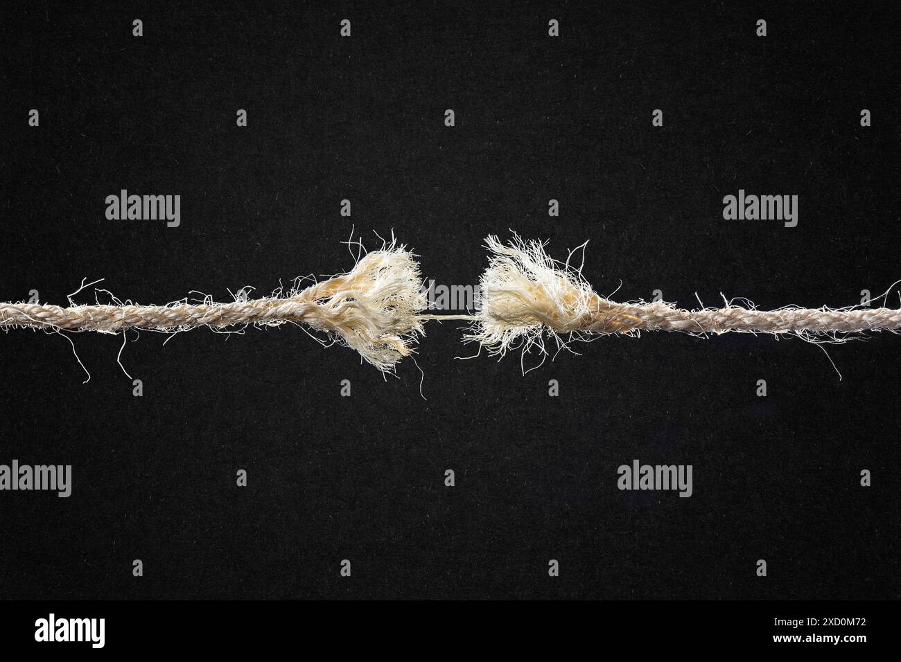 Frayed Rope About to Break Against Textured Black Paper Background with ...