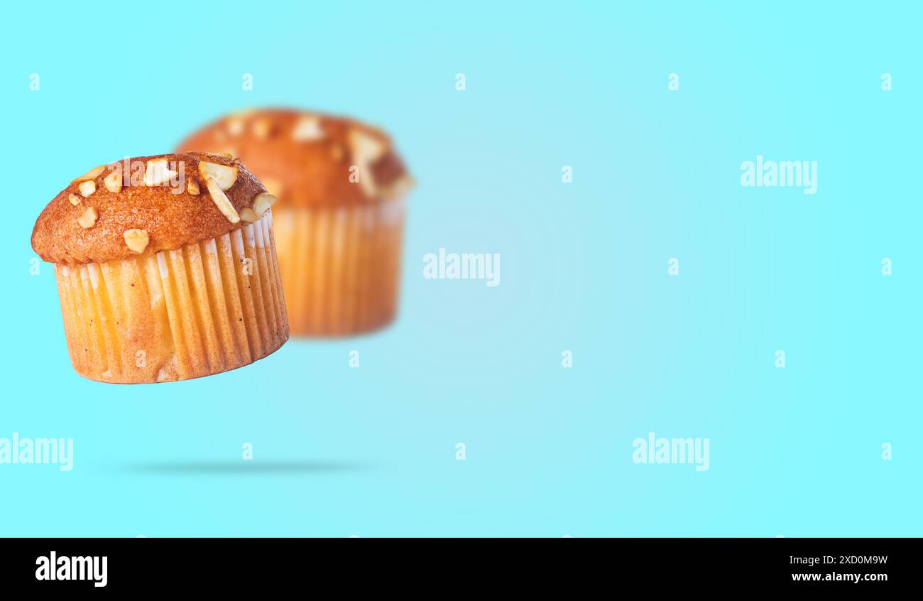 Almond muffins flying isolated on blue background with space for your ...