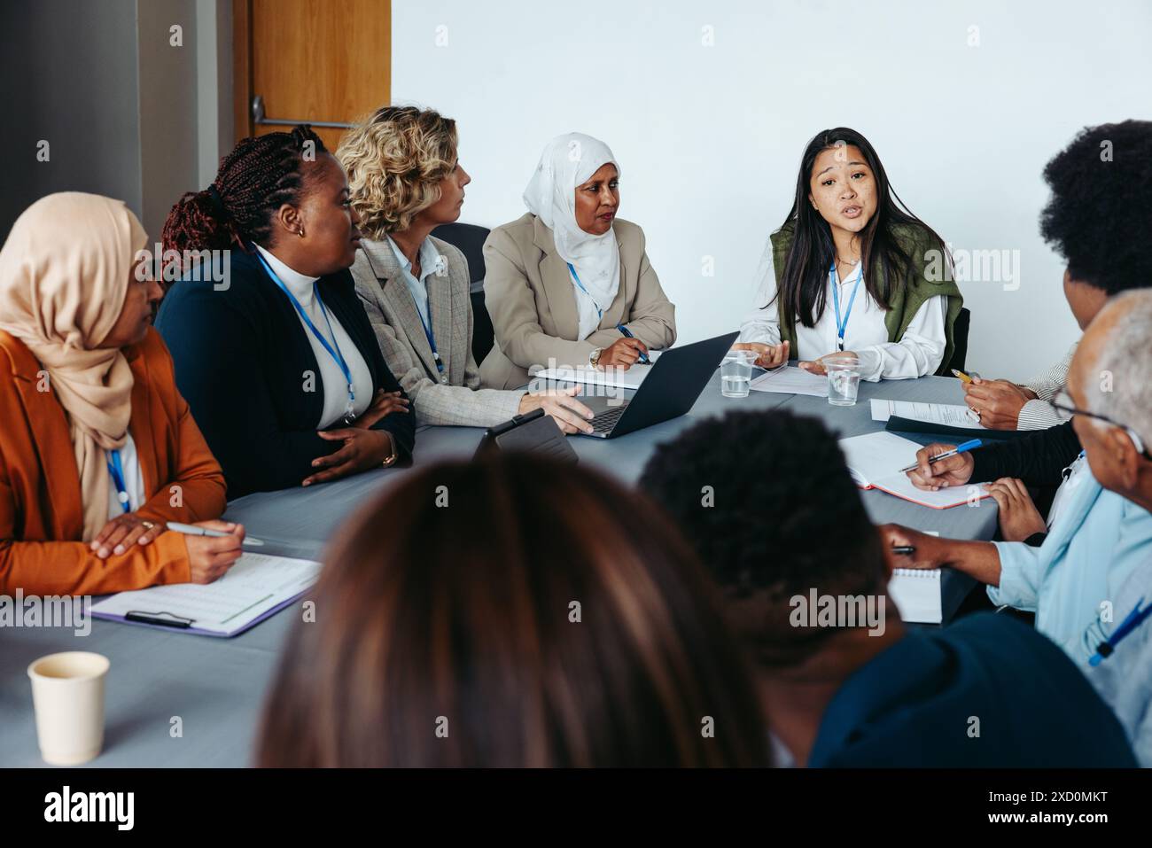 Diverse group of professionals in business meeting. Team members discussing ideas around a ...