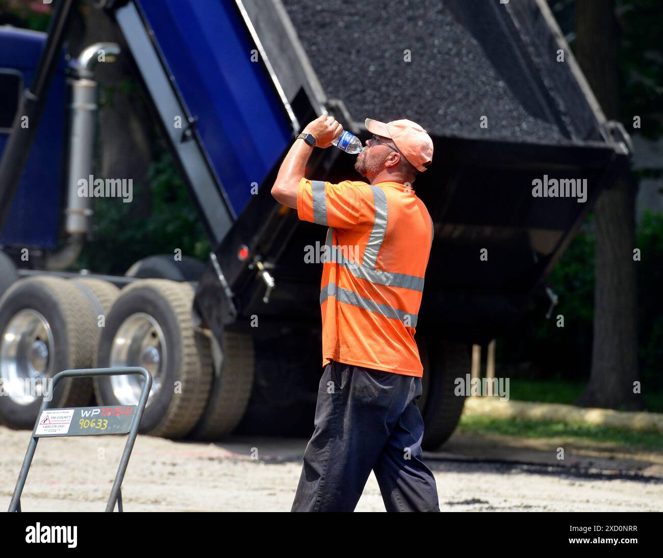 Chad Welch of Holyoke chugs water while laying asphalt at Kenefick park ...
