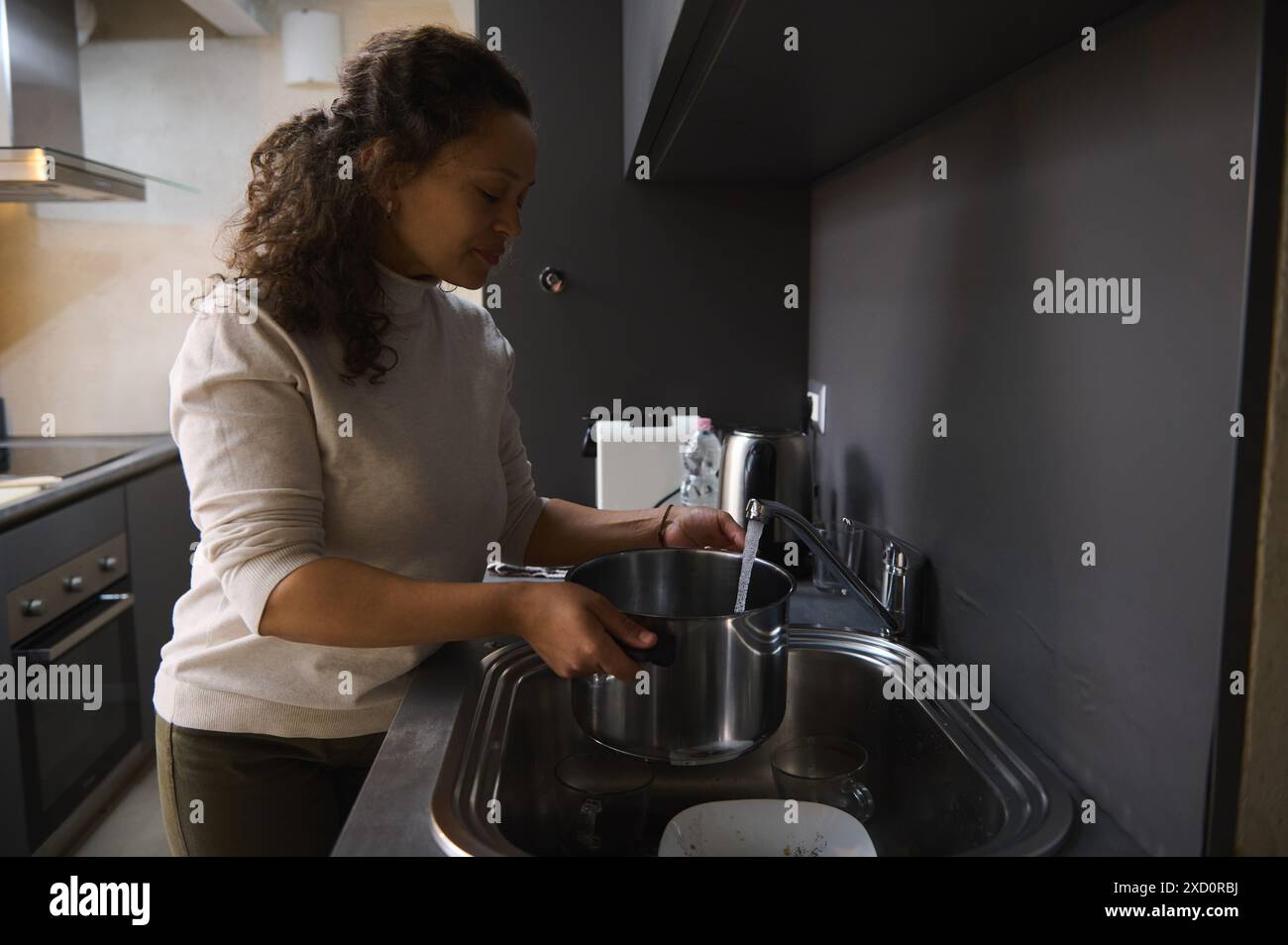Woman washes cooking utensils hi-res stock photography and images - Alamy