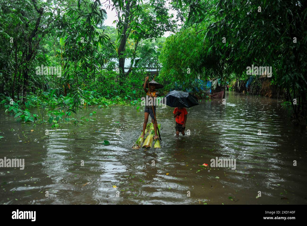 Sylhet, Bangladesh. 18th June, 2024. Children on bamboo raft on flood ...