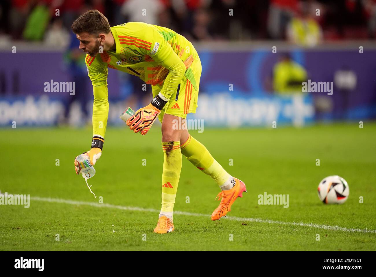 Scotland goalkeeper Angus Gunn collects cups thrown onto the pitch ...