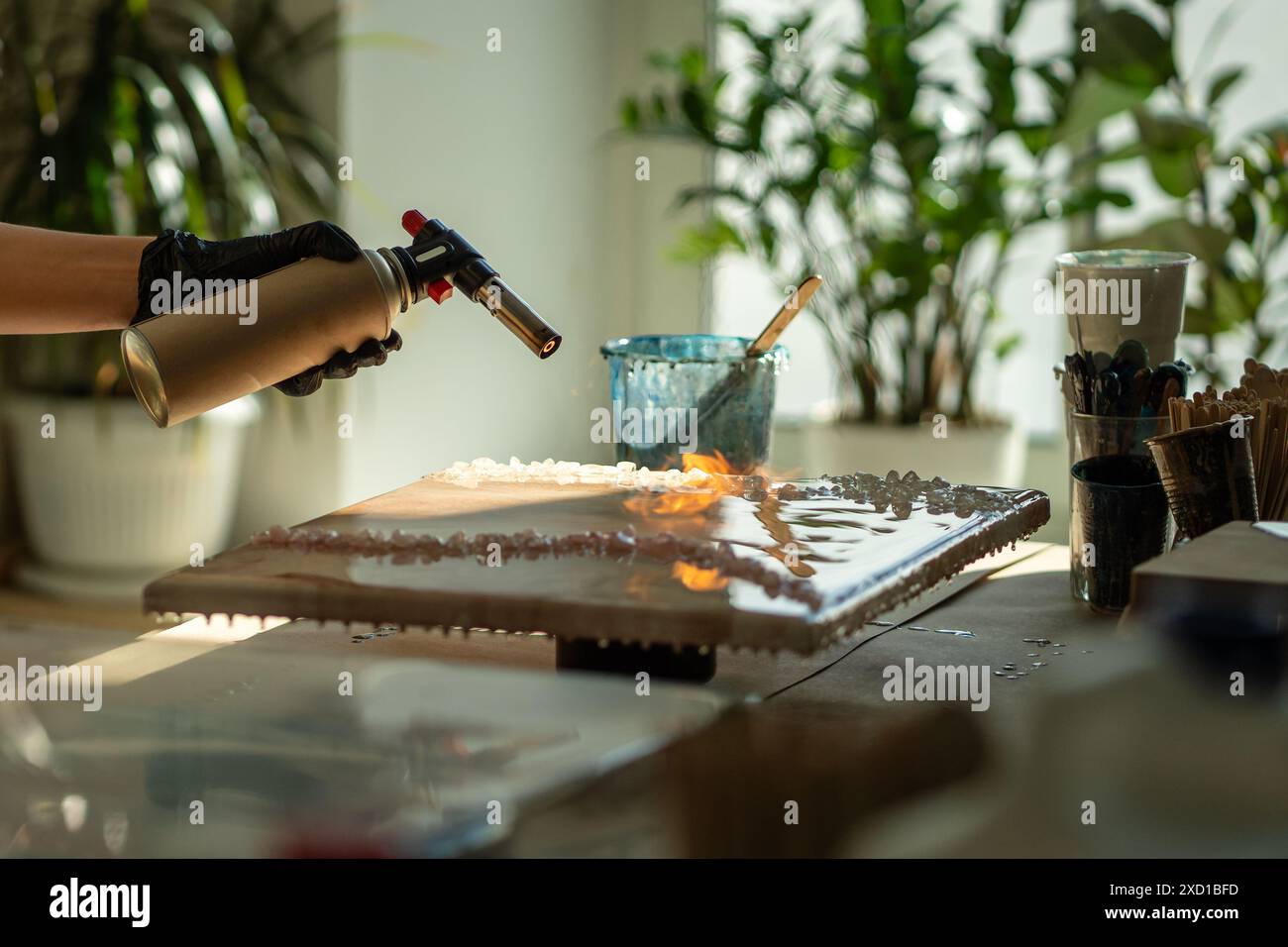 Palm of professional female artist works with burner, processing epoxy ...