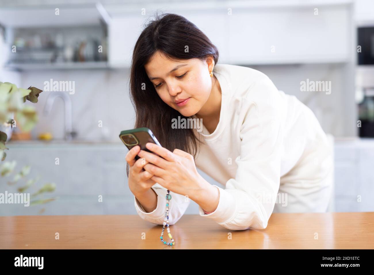 Young woman scrolling through social media on smartphone at home Stock ...