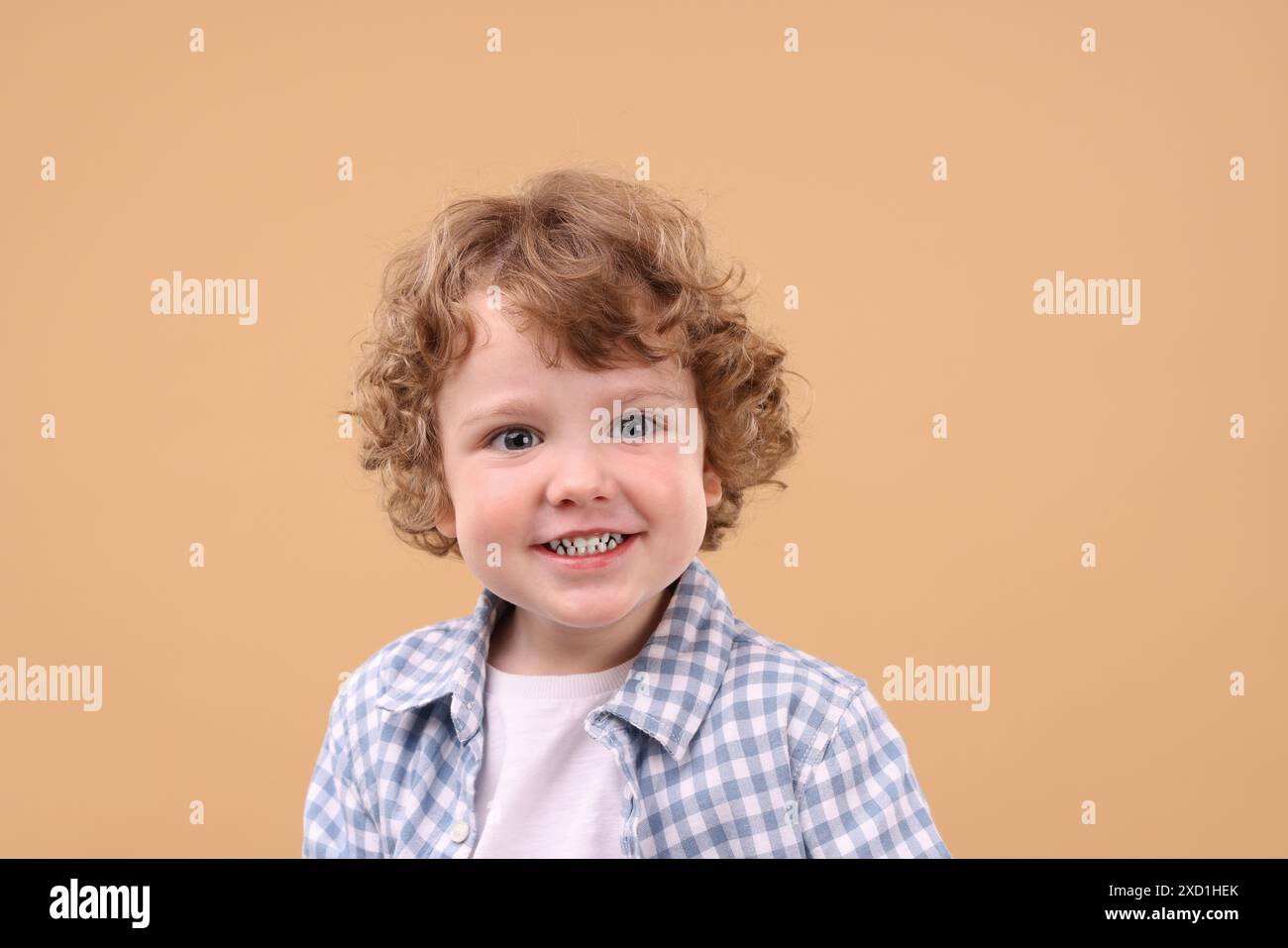 Portrait of cute little boy on beige background Stock Photo - Alamy