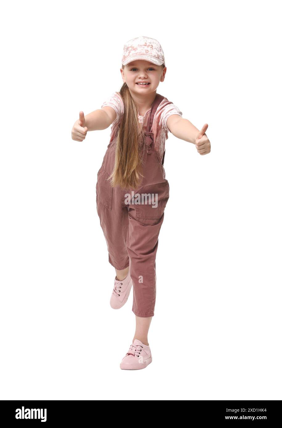 Cute little girl showing thumbs up while dancing on white background ...