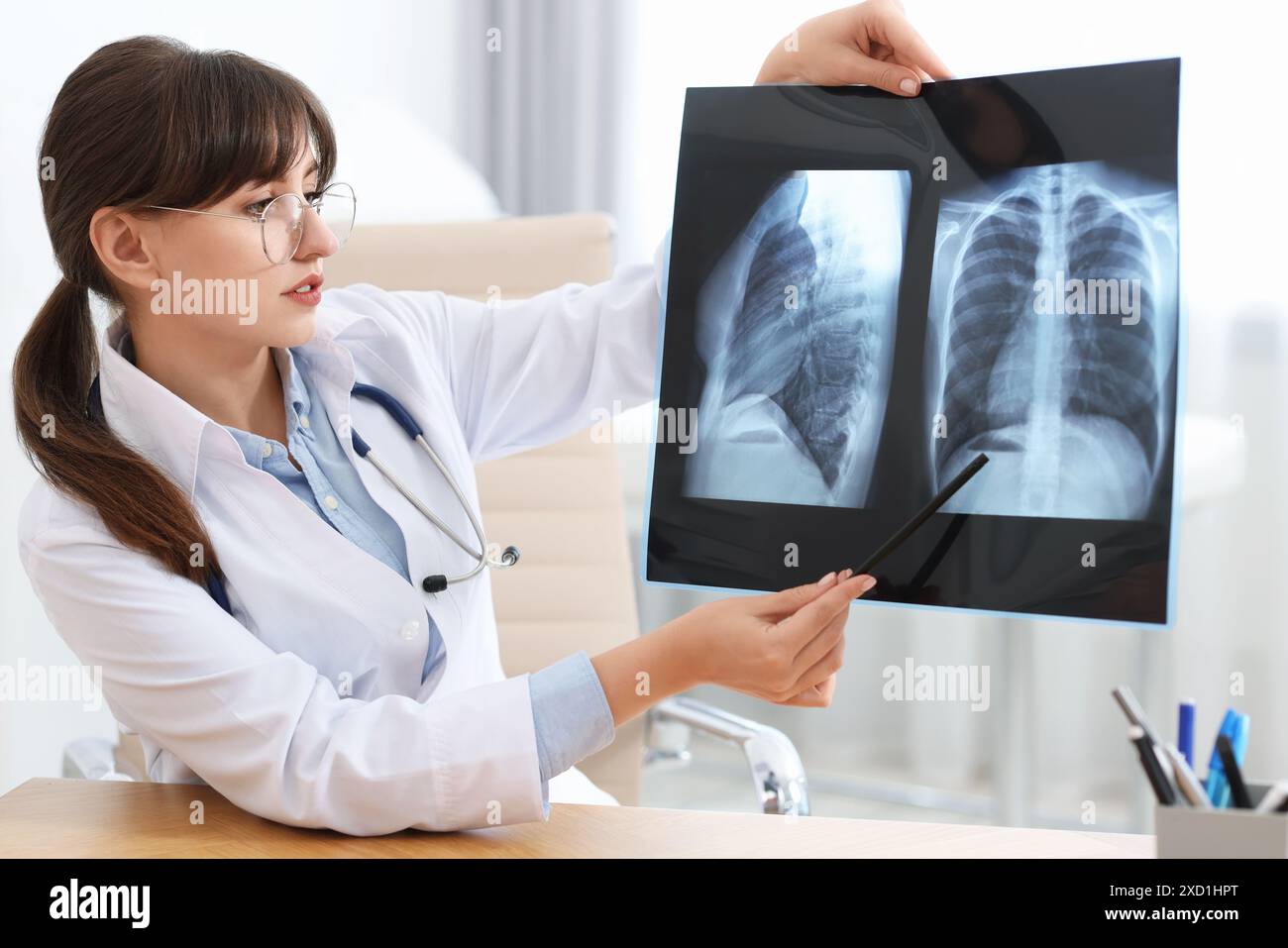 Lung disease. Doctor examining chest x-ray at table in clinic Stock ...