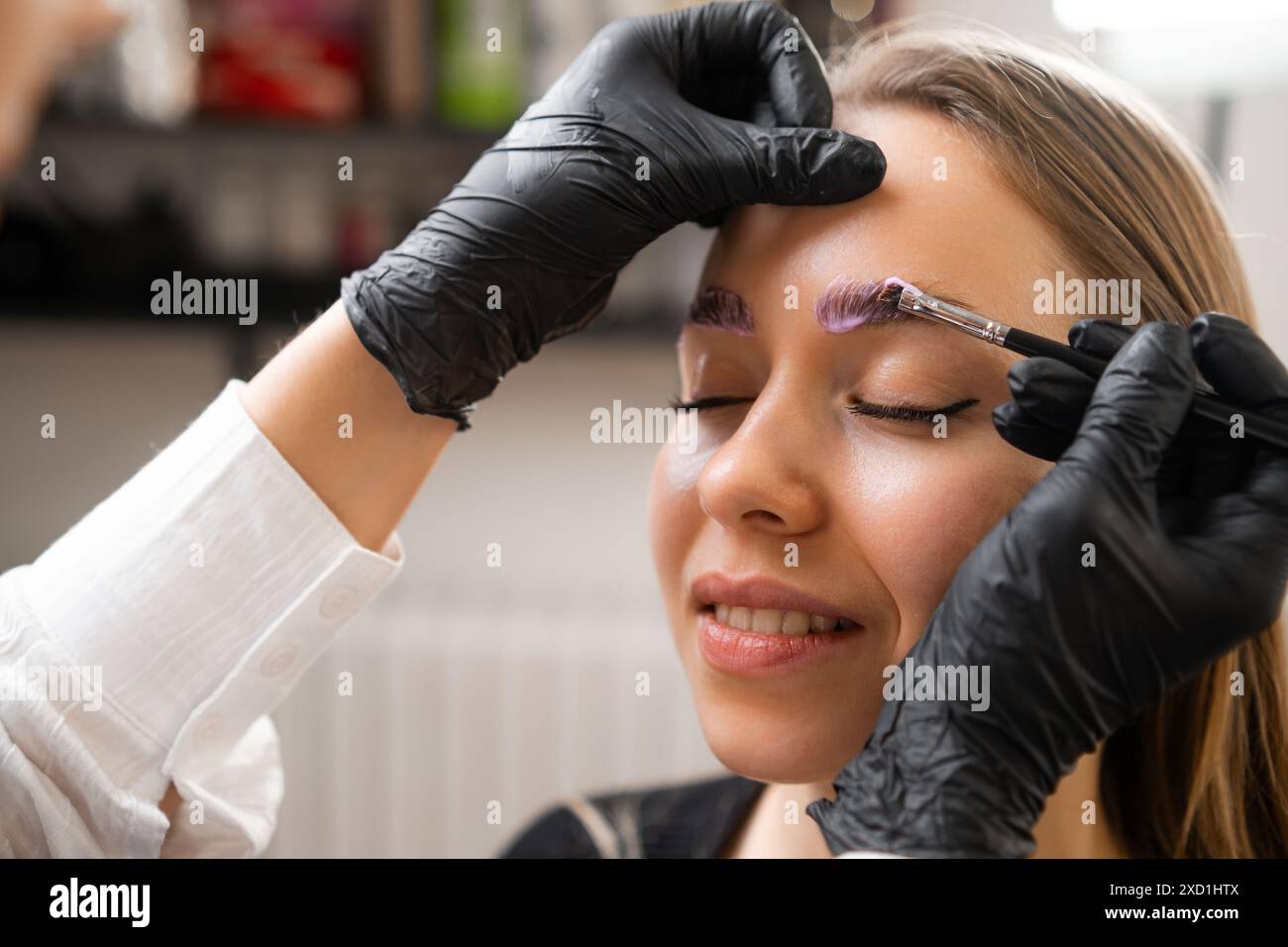 A woman is having her eyebrows laminated by a professional Stock Photo ...