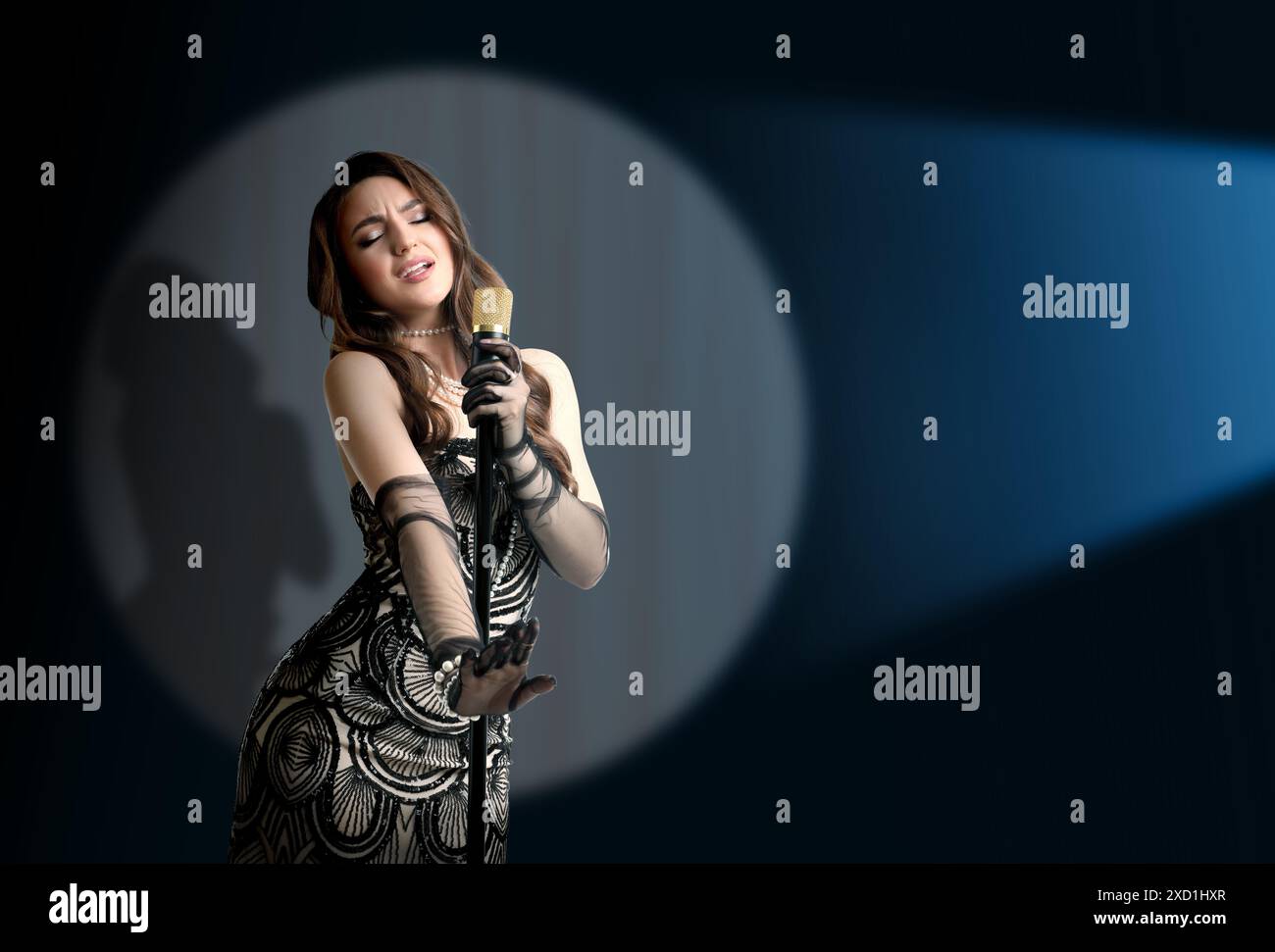 Beautiful singer performing in spotlight on stage Stock Photo - Alamy