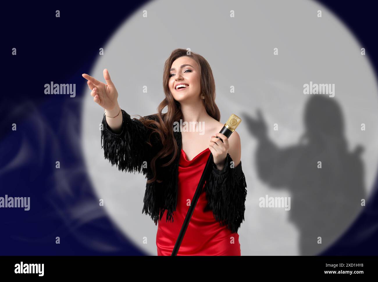 Beautiful singer performing in spotlight on stage Stock Photo - Alamy