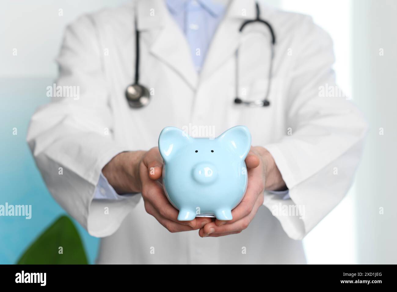 Male doctor holding piggy hi-res stock photography and images - Alamy