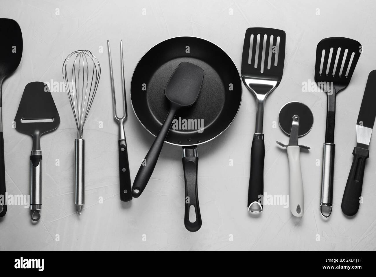 Different spatulas and other kitchen utensils on grey background, flat ...