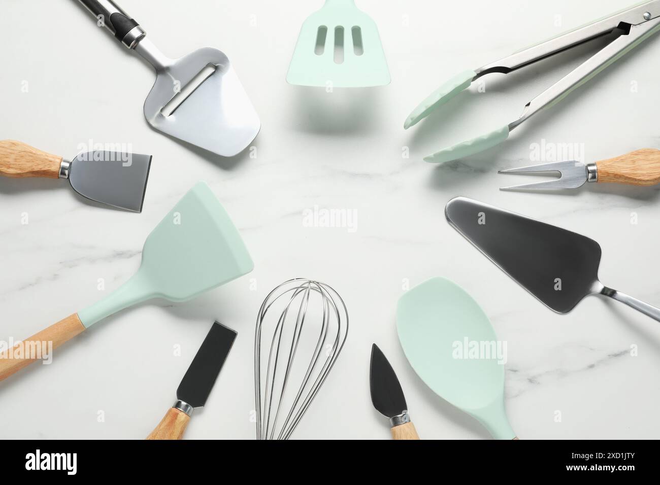 Frame of different spatulas and other kitchen utensils on light marble ...