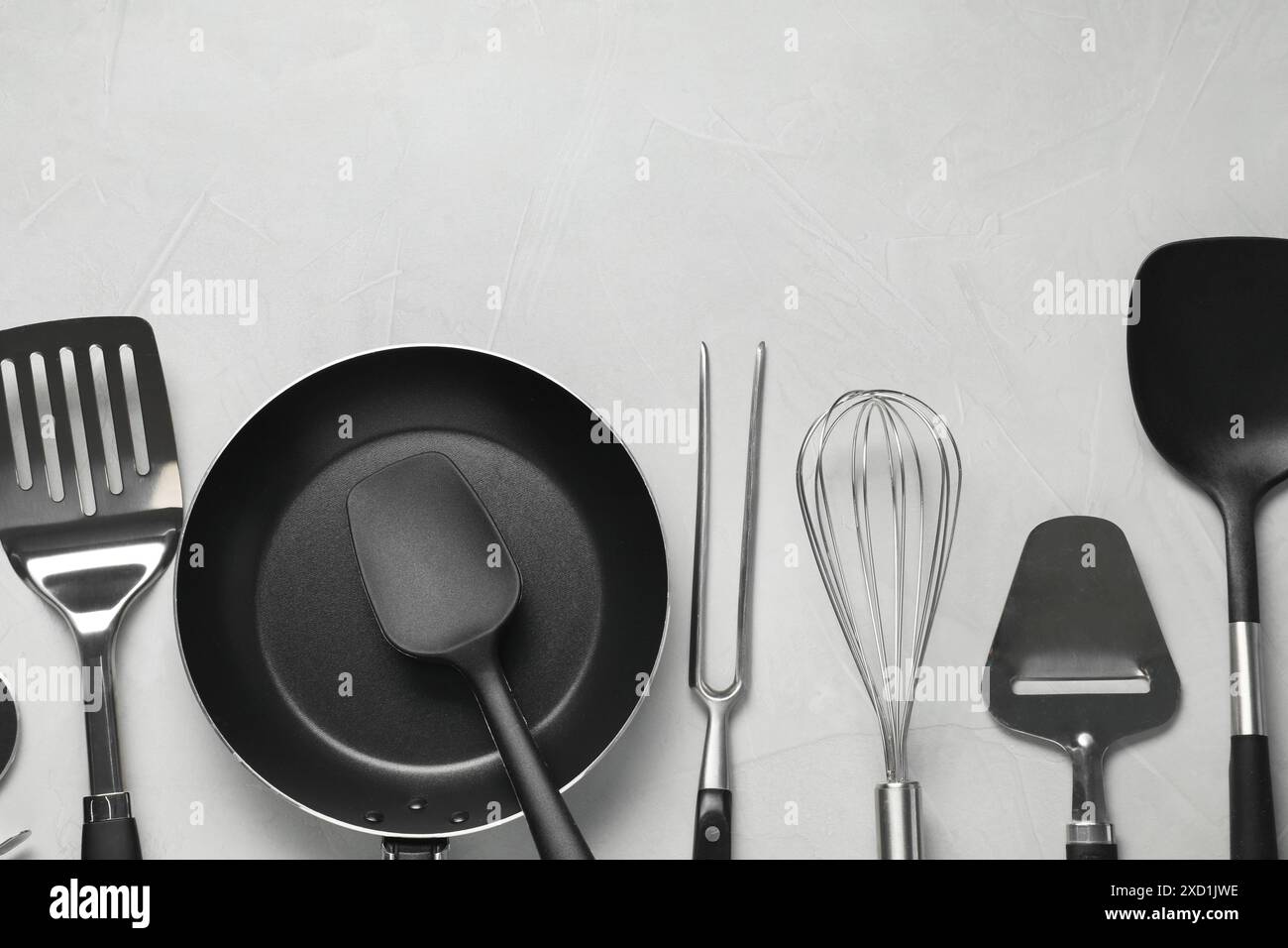 Different spatulas and other kitchen utensils on grey background, flat ...