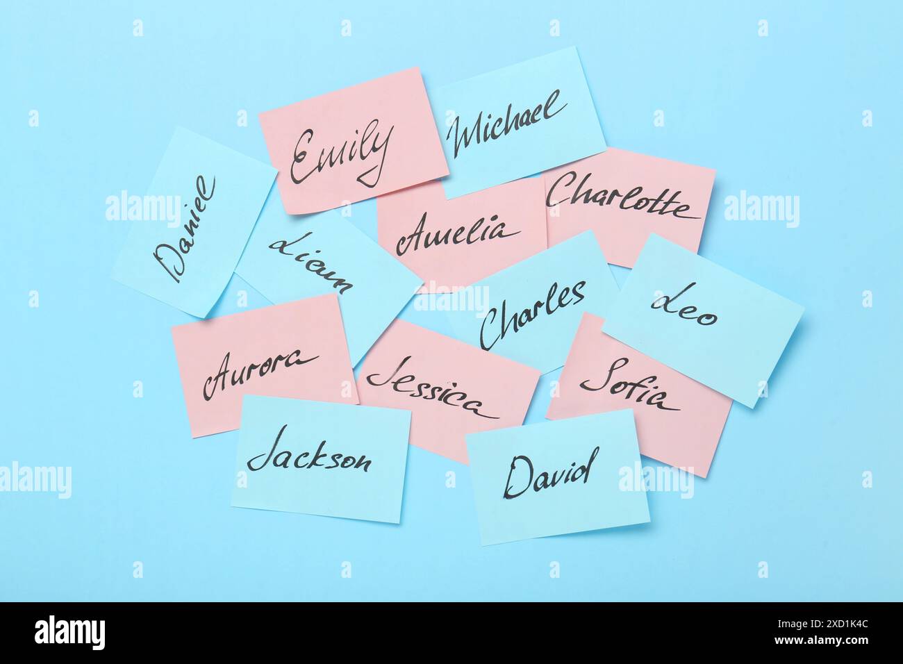 Paper stickers with different names on light blue background, top view ...