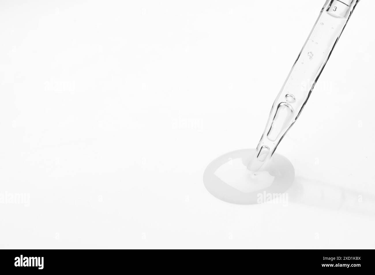 Glass pipette and transparent liquid on white background, closeup ...