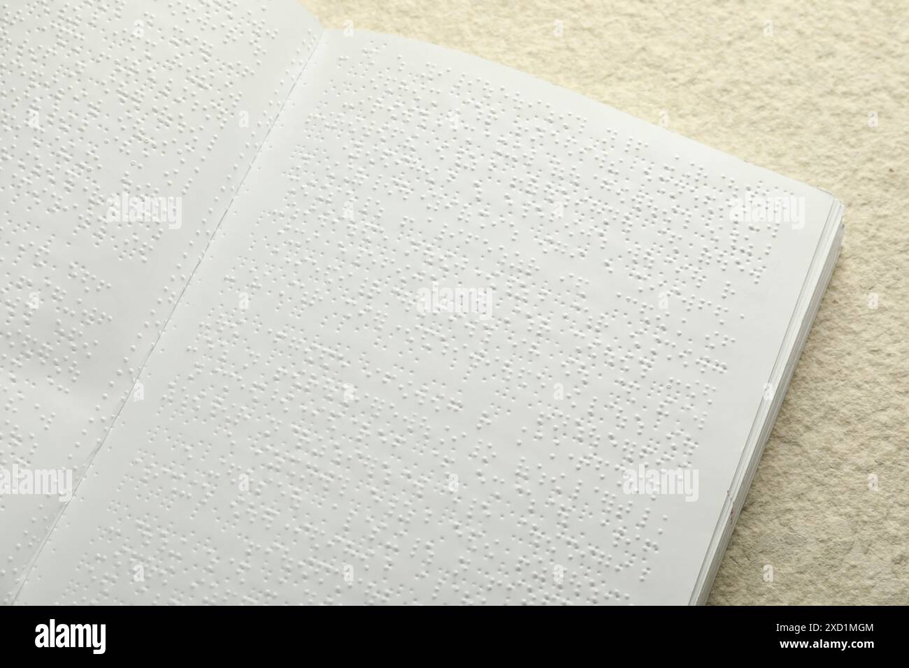Book with Braille text on beige textured table, top view. Education and ...