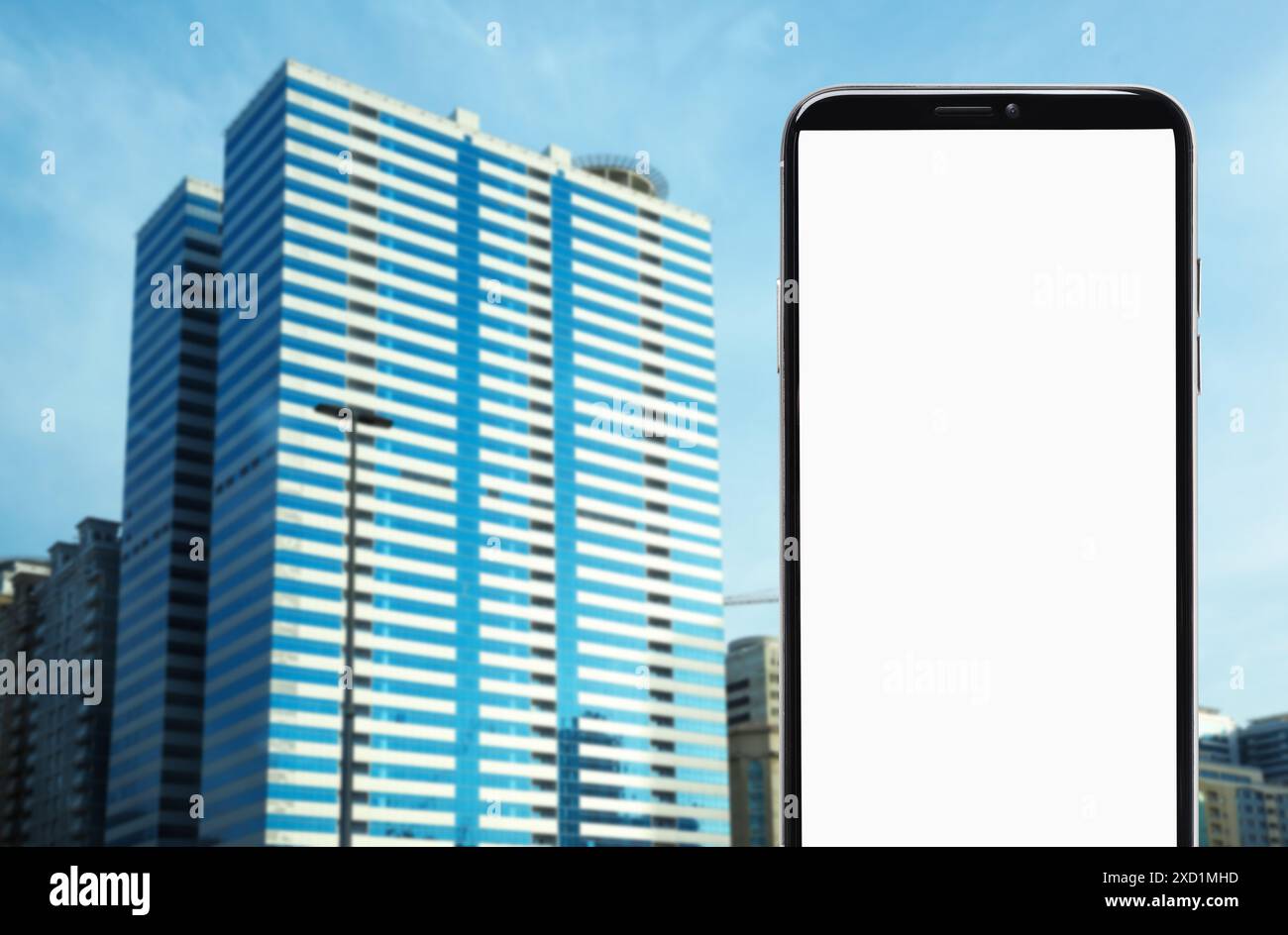 Mobile phone with empty screen against buildings. Space for design ...