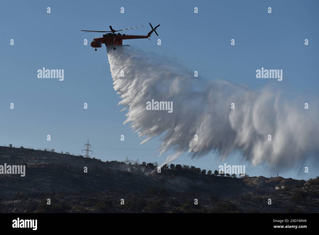 Fire breaks out in Koropi near Athens A firefighting helicopter drops ...