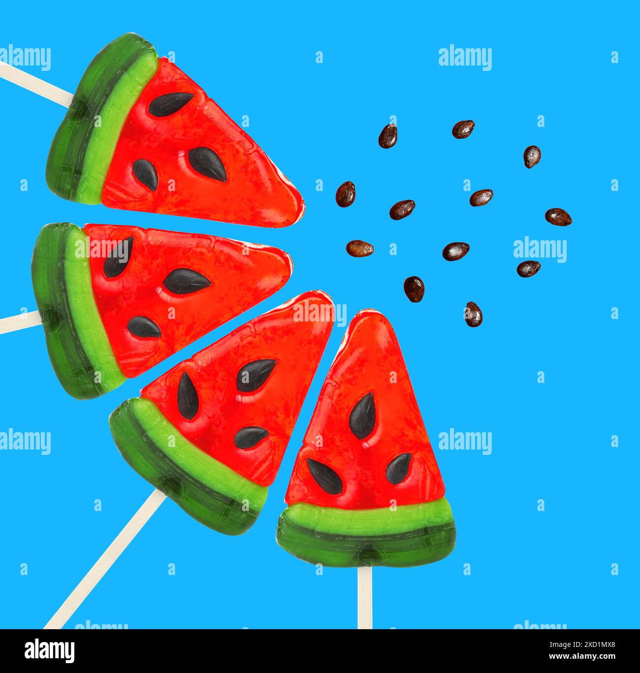 Sweet watermelon shaped lollipops and seeds on blue background ...
