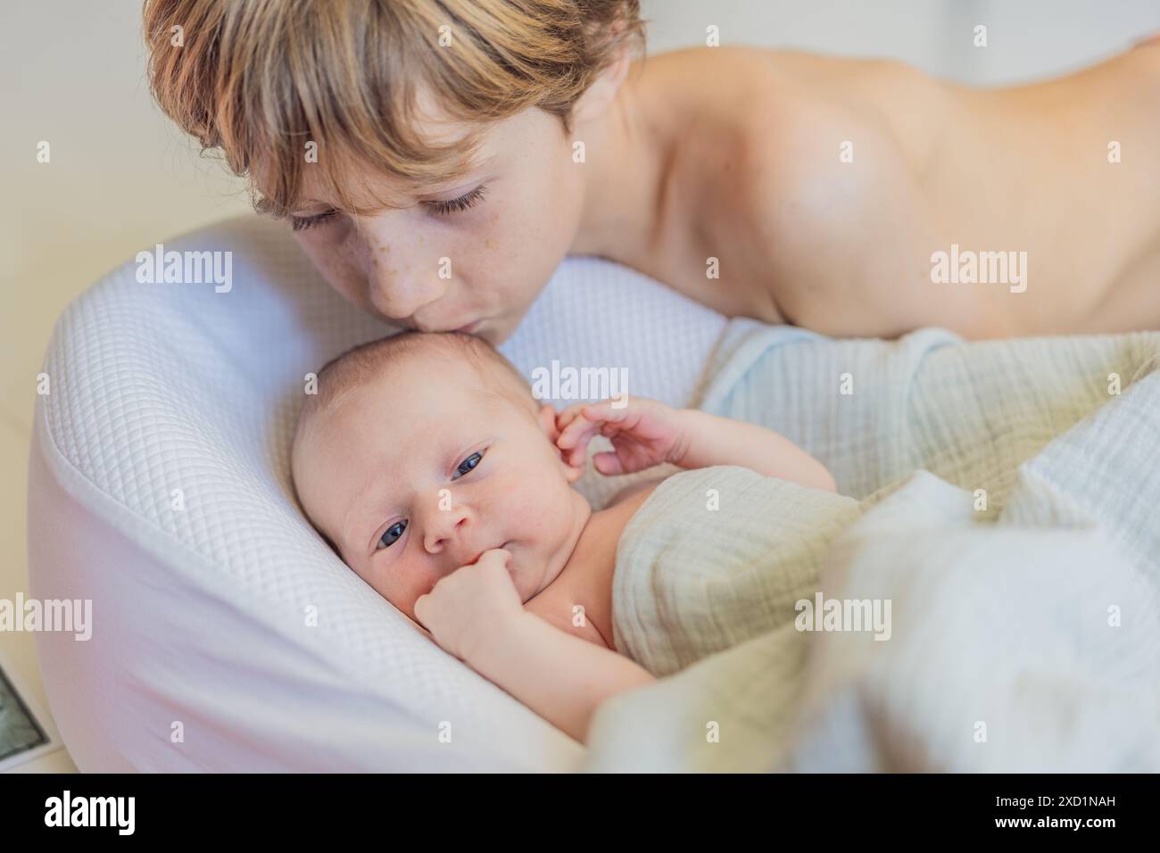 Older brother kisses newborn baby brother. This heartwarming moment ...