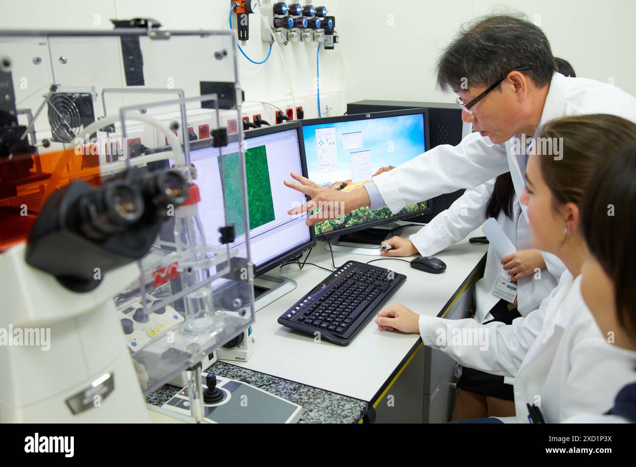 Teacher and students. Inverted optical microscope. With incubator ...