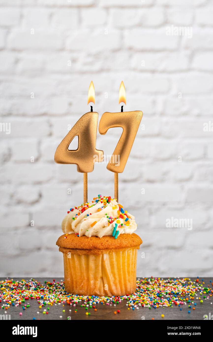 Golden birthday candle number 47 with cupcake - White block wall ...