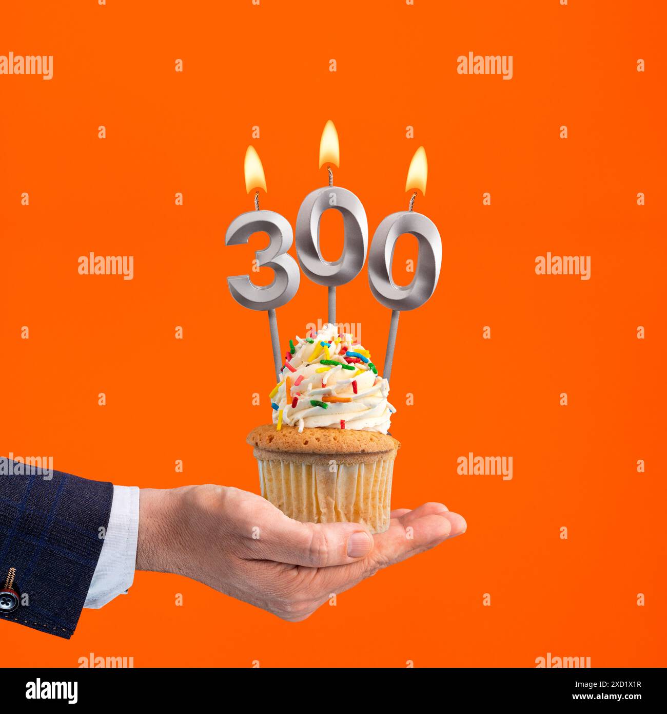 Hand holding birthday cupcake with number 300 candle - background ...
