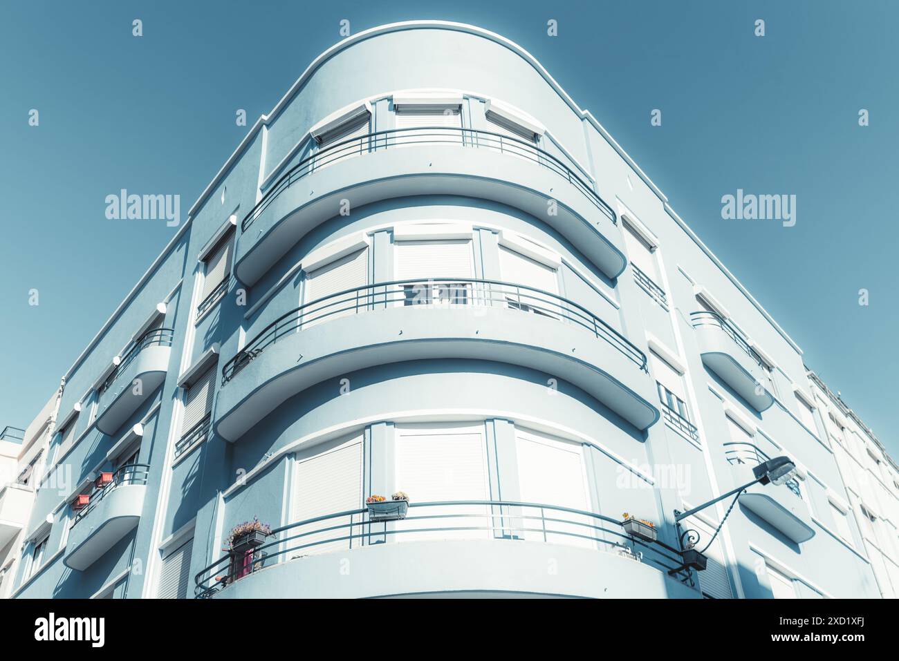 A modern residential building with curved balconies and blue exterior ...