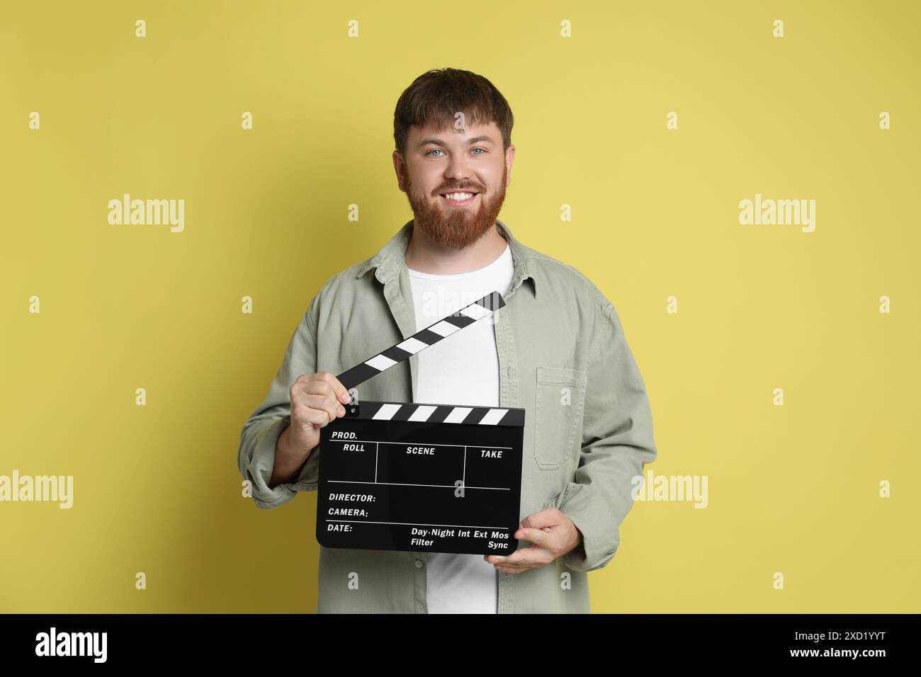Making movie. Smiling man with clapperboard on yellow background Stock ...
