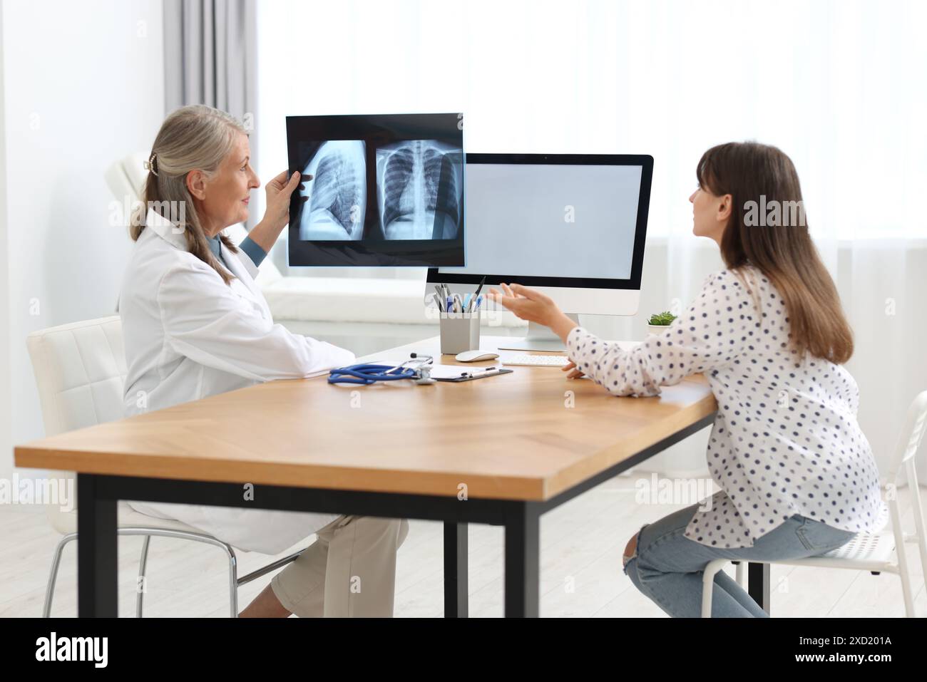 Lung disease. Doctor showing chest x-ray to her patient in clinic Stock ...
