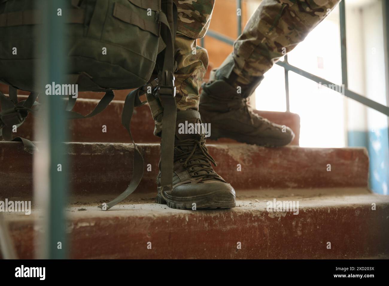 Military mission. Soldier in uniform on stairs inside abandoned ...