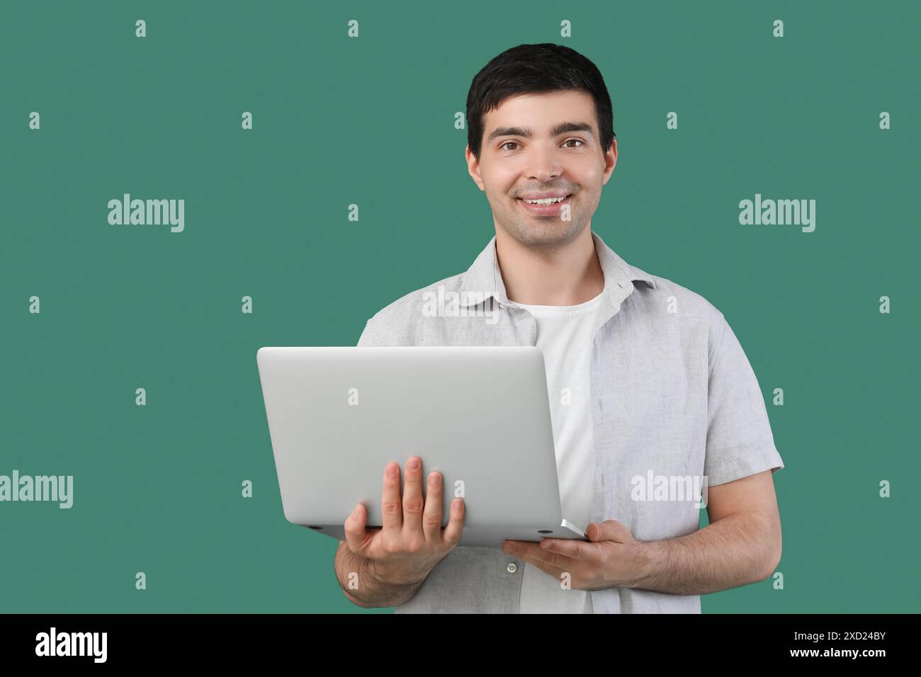 Male programmer working with laptop on green background Stock Photo - Alamy