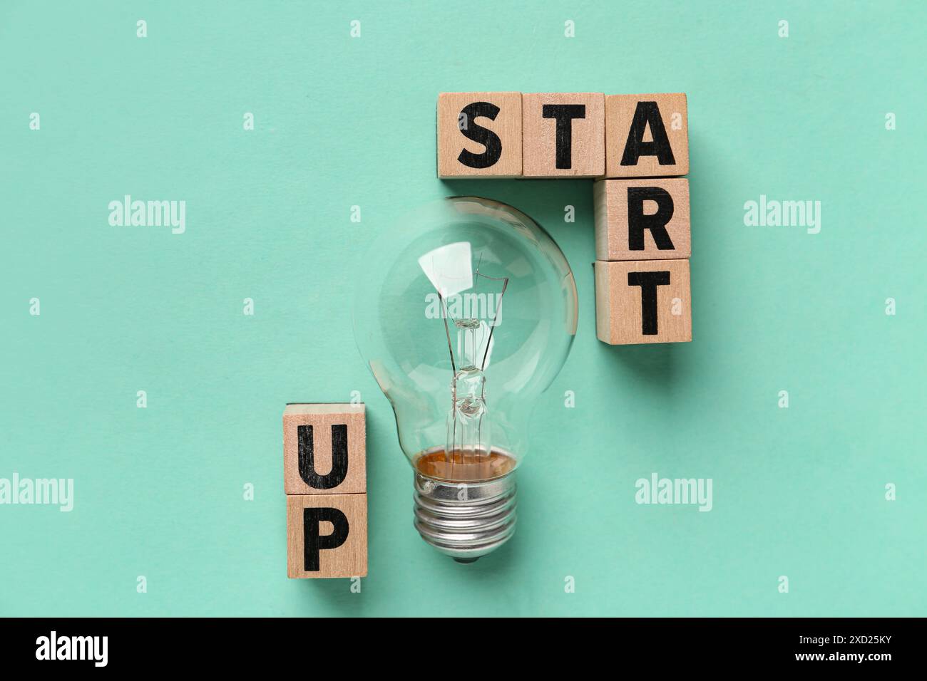 Cubes with word STARTUP and light bulb on green background Stock Photo ...
