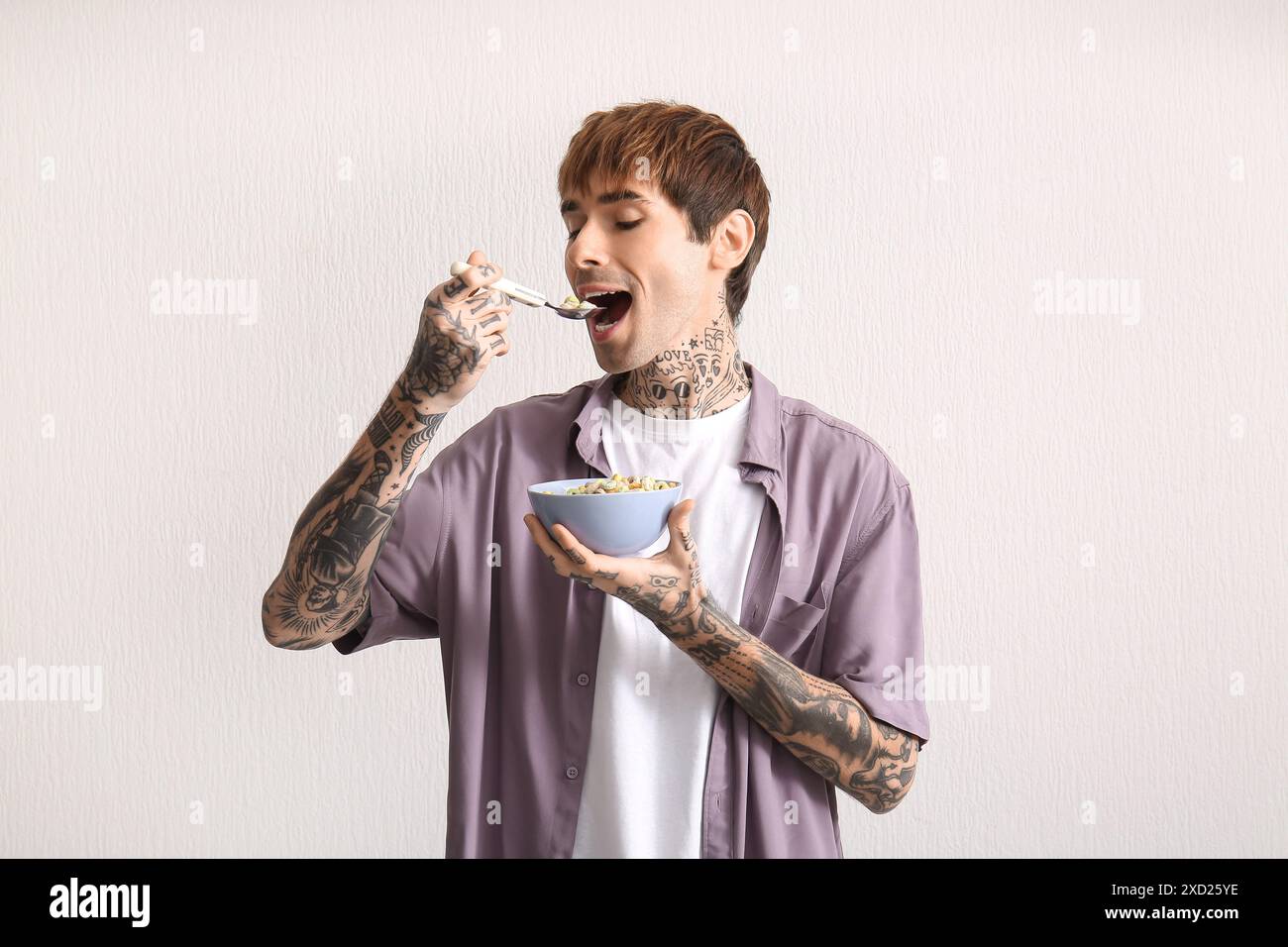 Man eating cereal rings on white textured background Stock Photo - Alamy