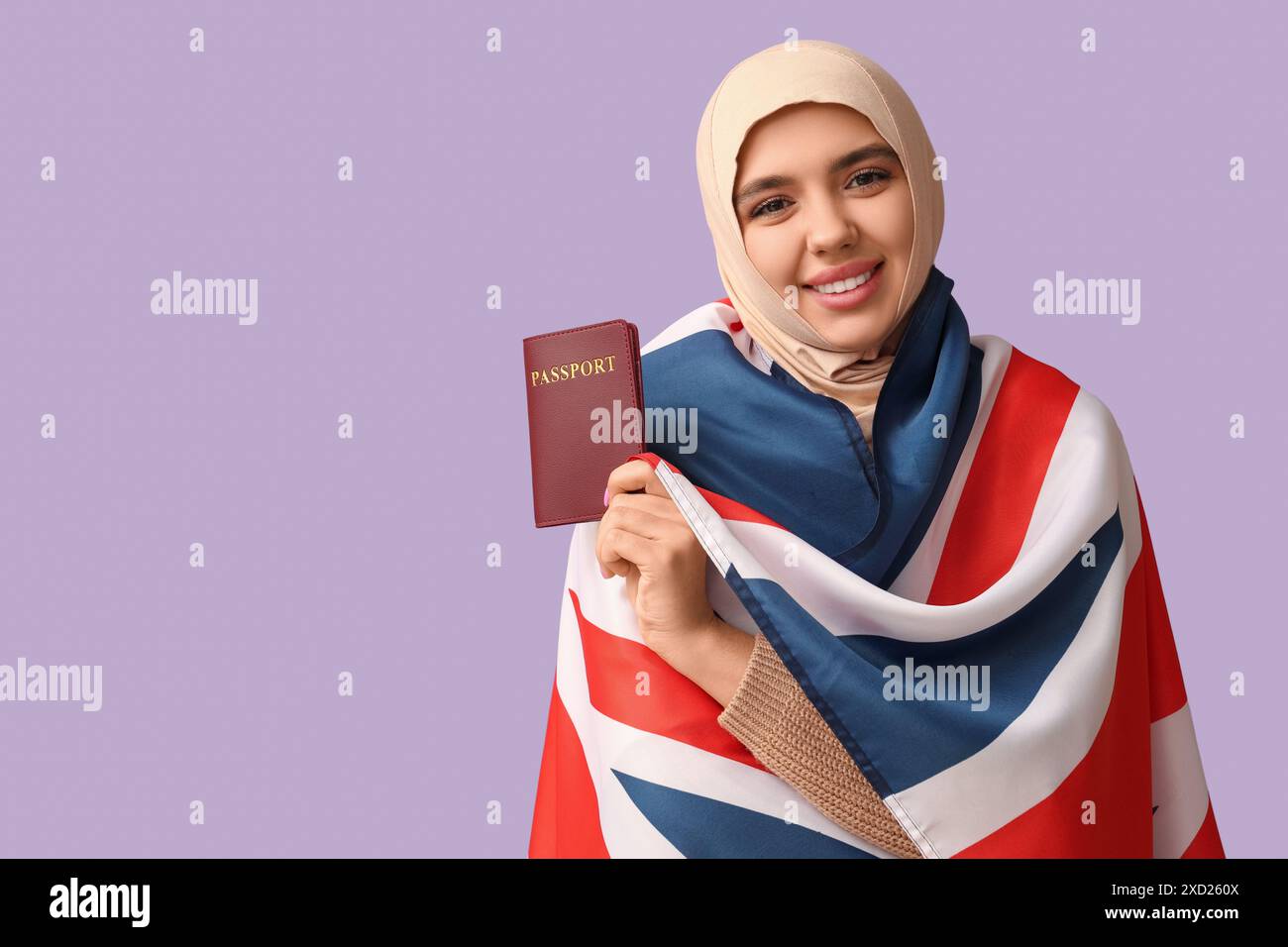 Beautiful young Muslim woman with UK flag and passport on purple ...