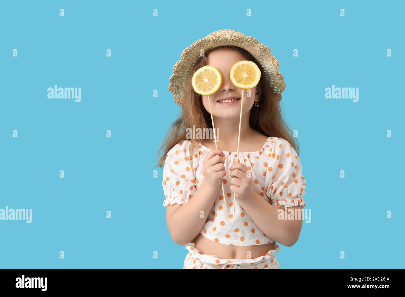 Cute little girl with lemon slices on blue background Stock Photo - Alamy