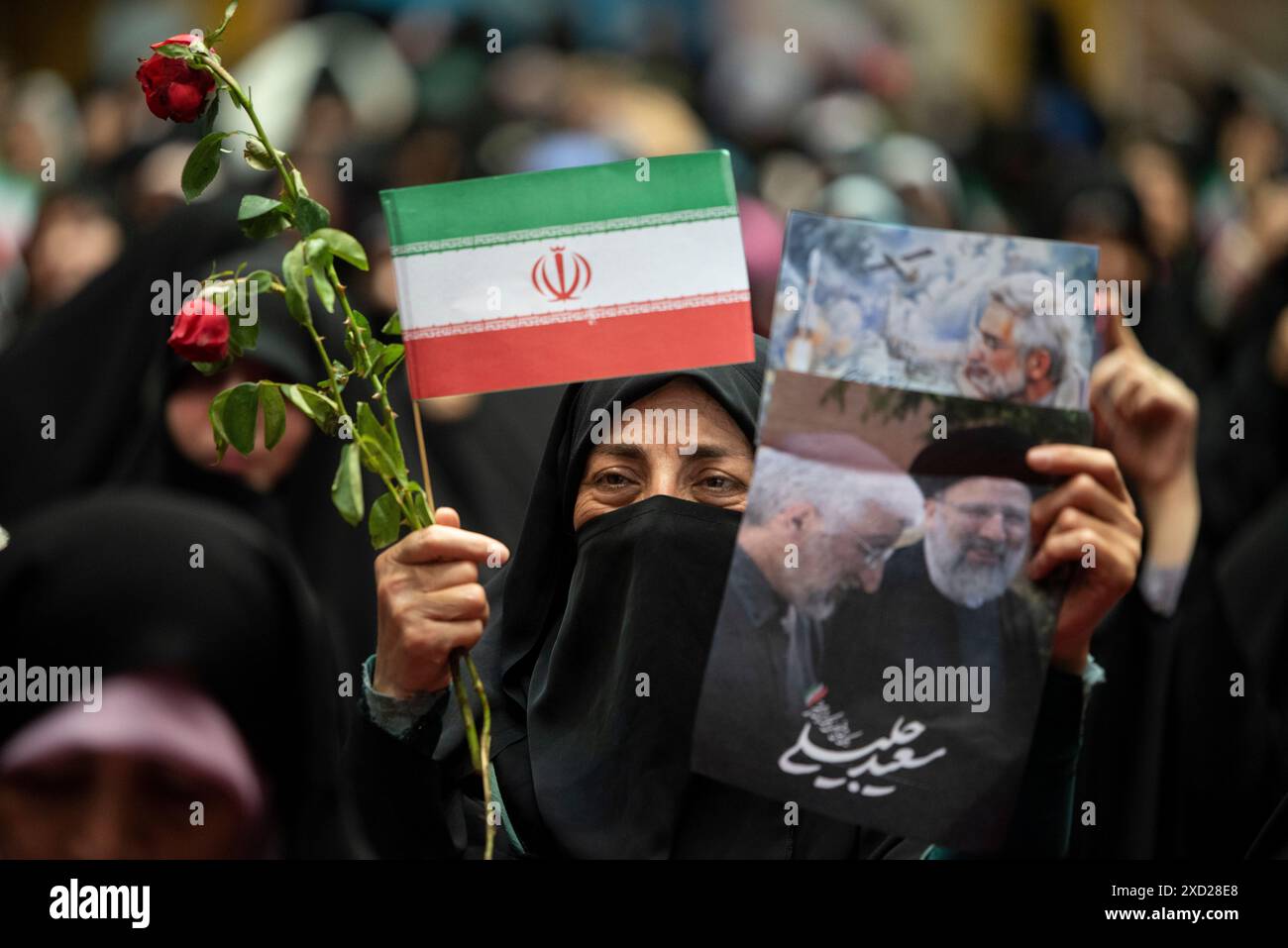 Tehran, Tehran, Iran. 19th June, 2024. A woman holds up an Iranian flag and a poster of Saeed ...